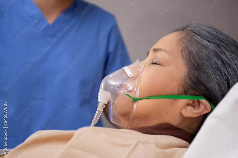 Nurse putting oxygen mask with patient elderly woman on bed for ...