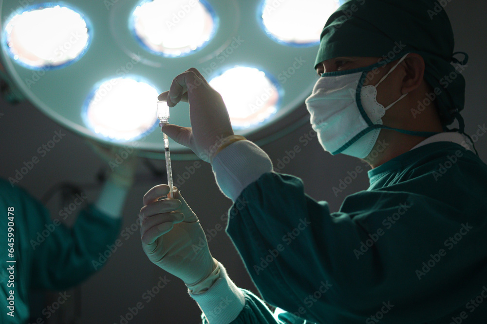 Professional surgeon doctor holding syringe, standing under bright ...