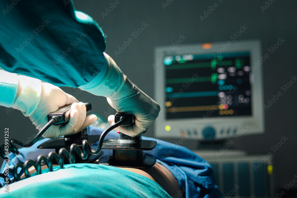 Surgeon doctor hand hold defibrillator to pump chest heart patient to ...