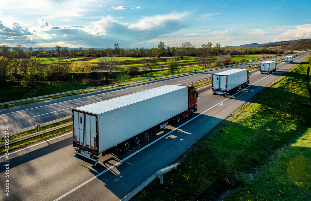 Large Transportation Trucks departing on a highway road through the ...