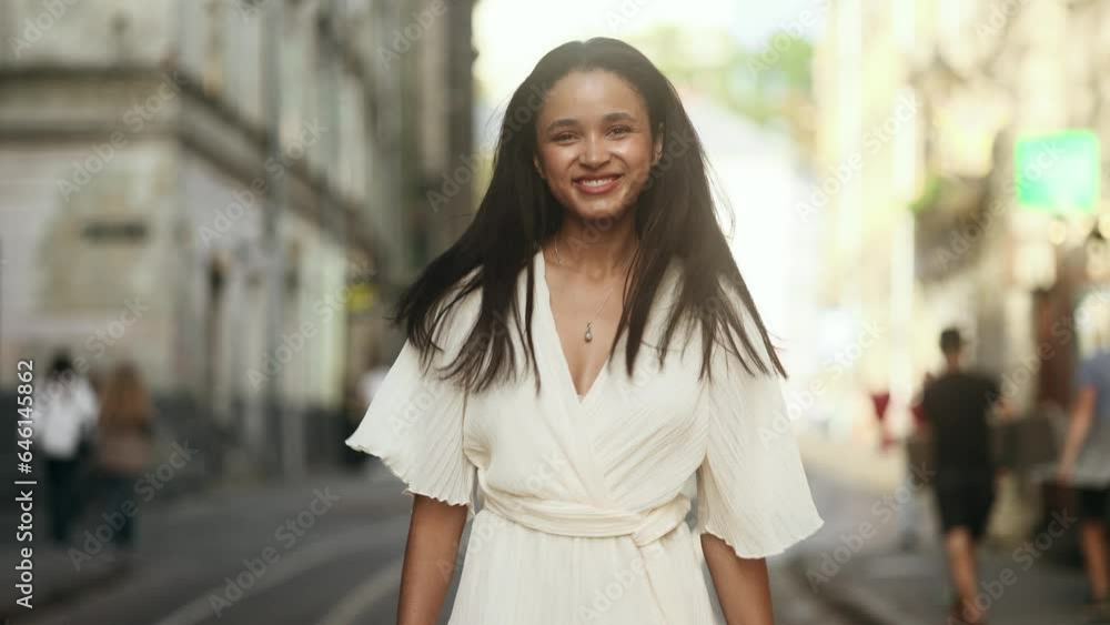 Charming young woman walking down the street turn around and looking at ...