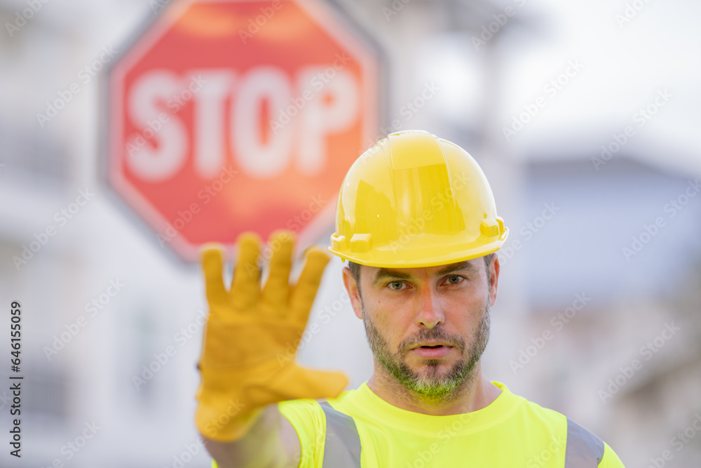 Builder showing STOP. Serious builder with stop road sign. Builder with ...