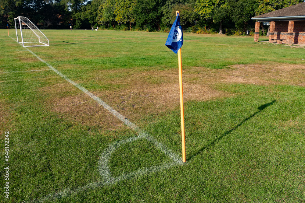 A corner flag and pitch markings at the corner of a football pitch in ...