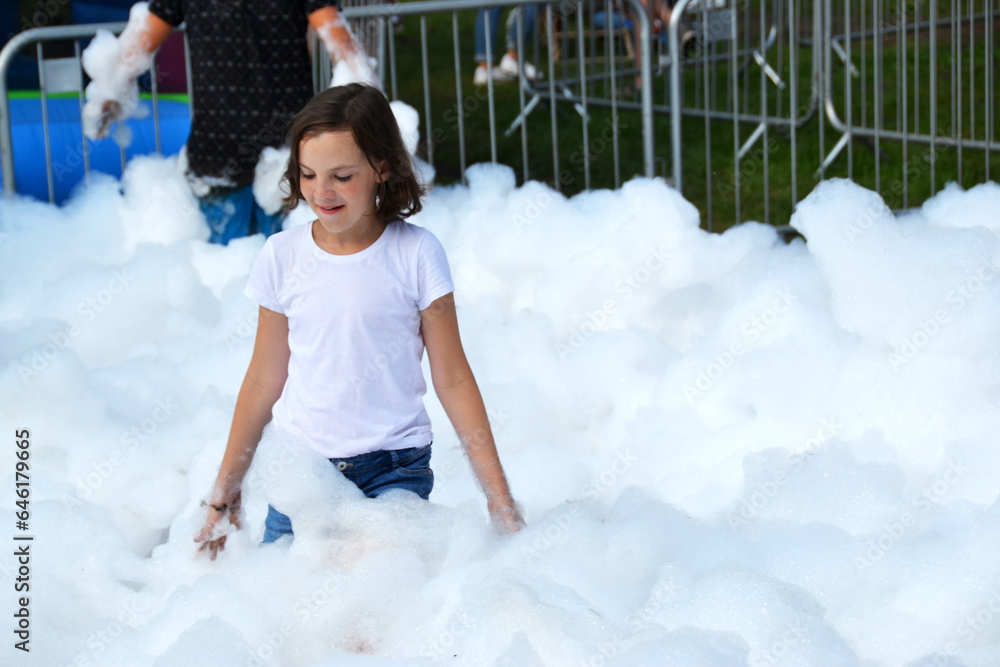 happy girl with foam on her head, in wet clothes at a foam party, in ...