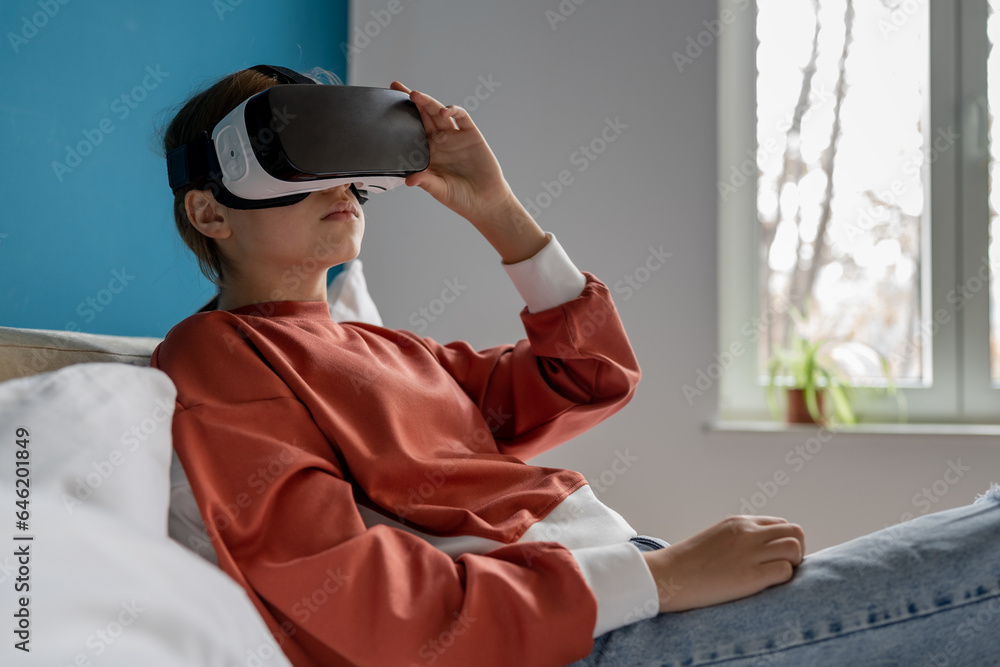 Relaxed teenage girl child in vr glasses watching 360-degree immersive ...
