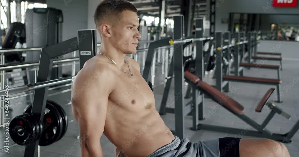 Side view on young handsome man with muscular body and abs sitting on ...