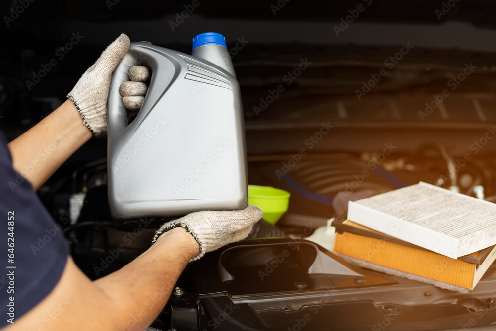 Car lubricant gallon or from gray bottle on engine background Oil ...