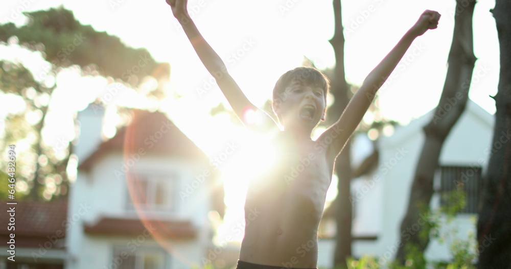 Boy raising arms in the sky clenching fists in victory and celebration ...