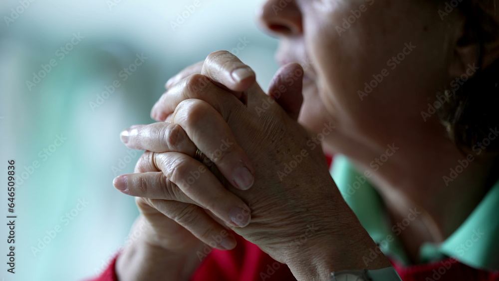 Close-up senior hands clenched in contemplation. Pensive body language ...
