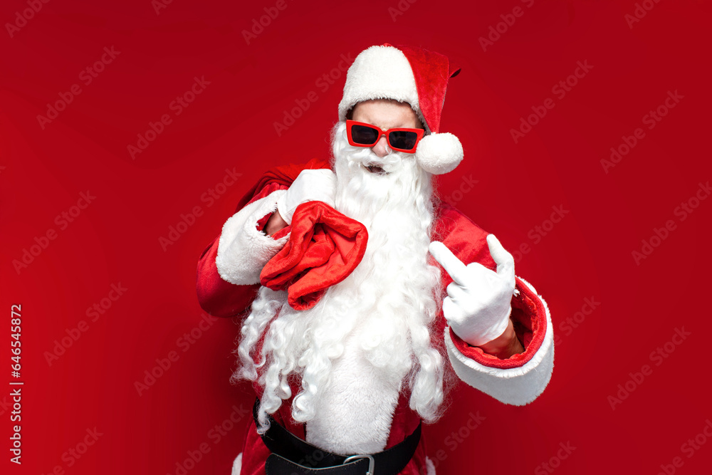 rude santa claus in cap and festive glasses showing middle finger on ...