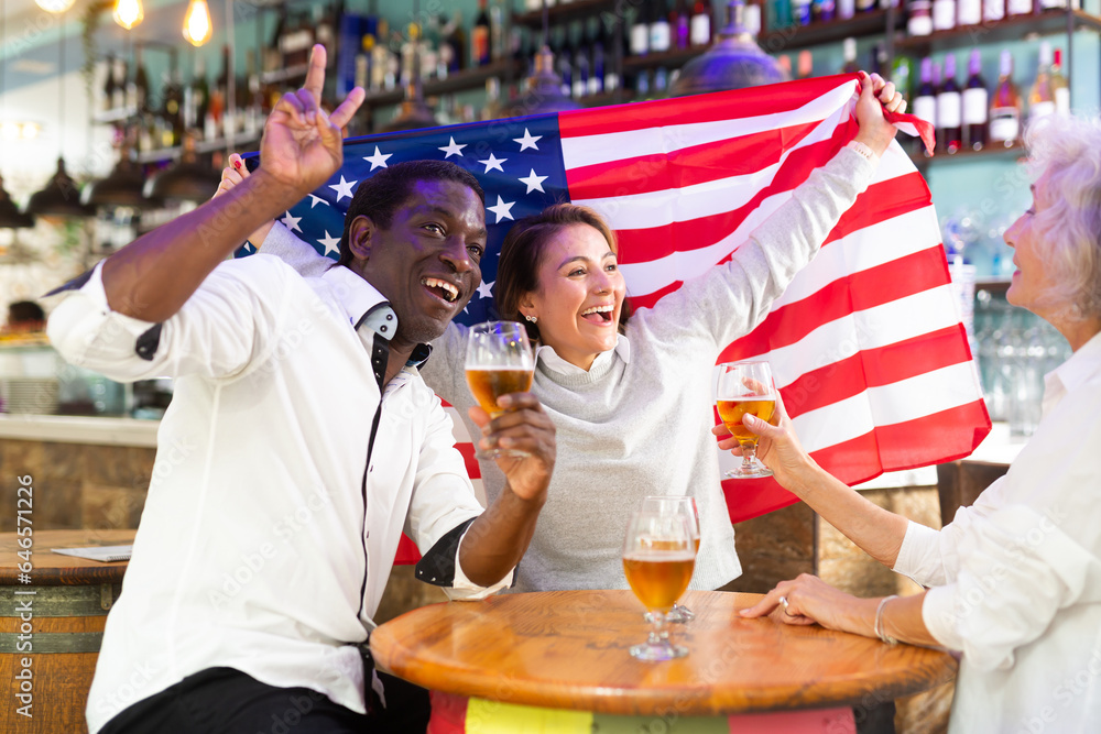 Happy diverse group celebrating the United States of America at a bar ...