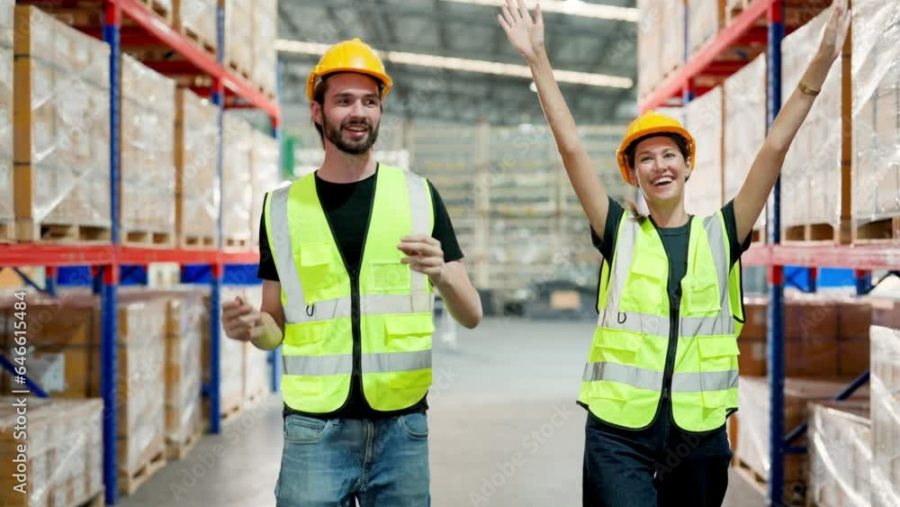 Young warehouse workers in uniform and helmet protective having fun and ...
