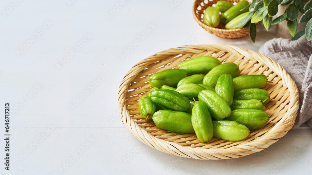green bilimbi kamias fruit in bamboo plate on white wood table ...