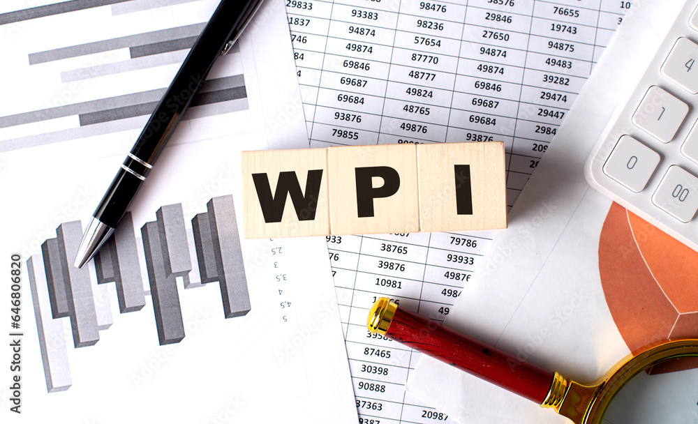 WPI text on wooden block on graph background with pen and magnifier ...