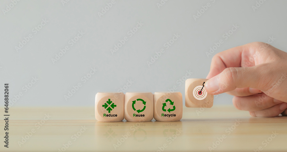 Hand arranging wood block with goal icon and Reduce, reuse, recycle ...