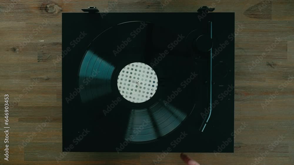 Male hands turn on classic vinyl record player, put black glossy disc ...