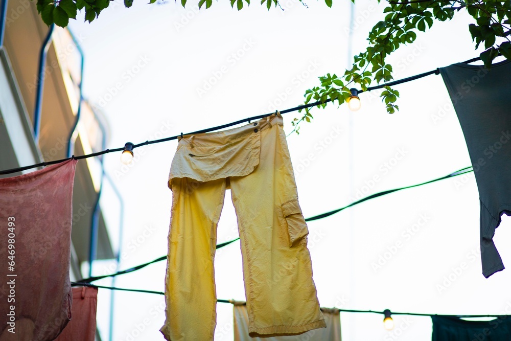 Hanging different clothes with clothespin with a rope on an outdoor ...
