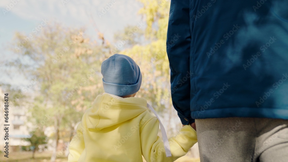 Child son holds dads hand, father, son walk together in park autumn ...
