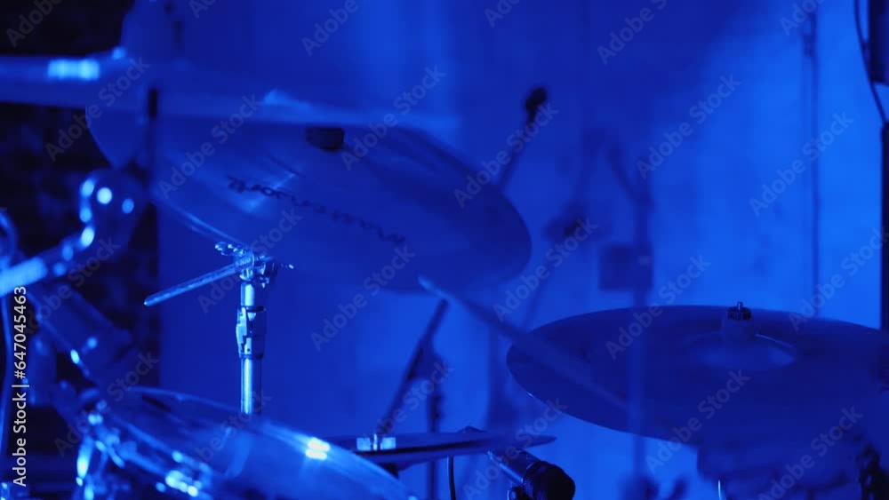 Close-up of a man playing drums. The drummer is actively using a cymbal ...