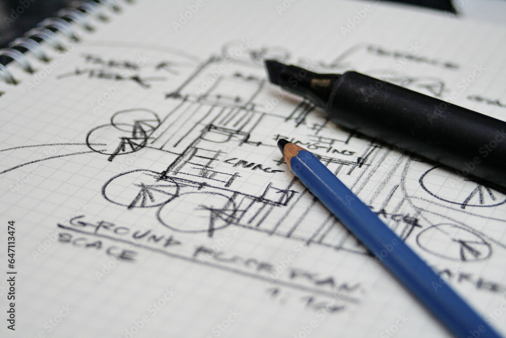sketching architectural plans with pencils on a sketchbook on a desk ...