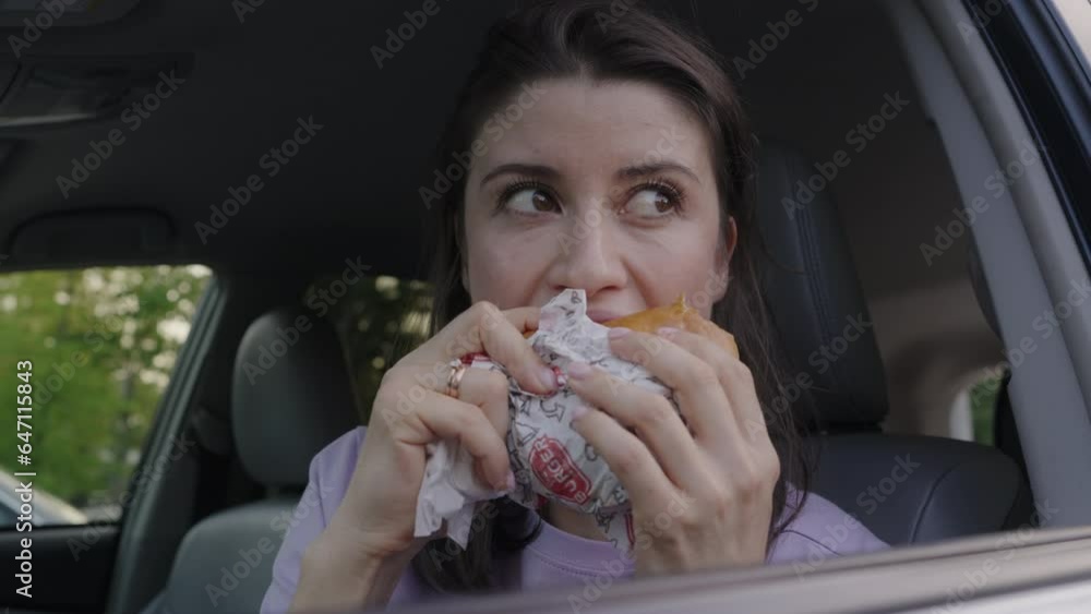 Woman eating delicious burger having nutritious snack for lunch in ...