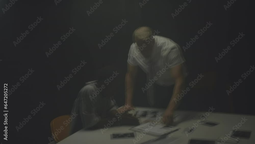 Through interrogation room window of mature FBI agent interviewing ...