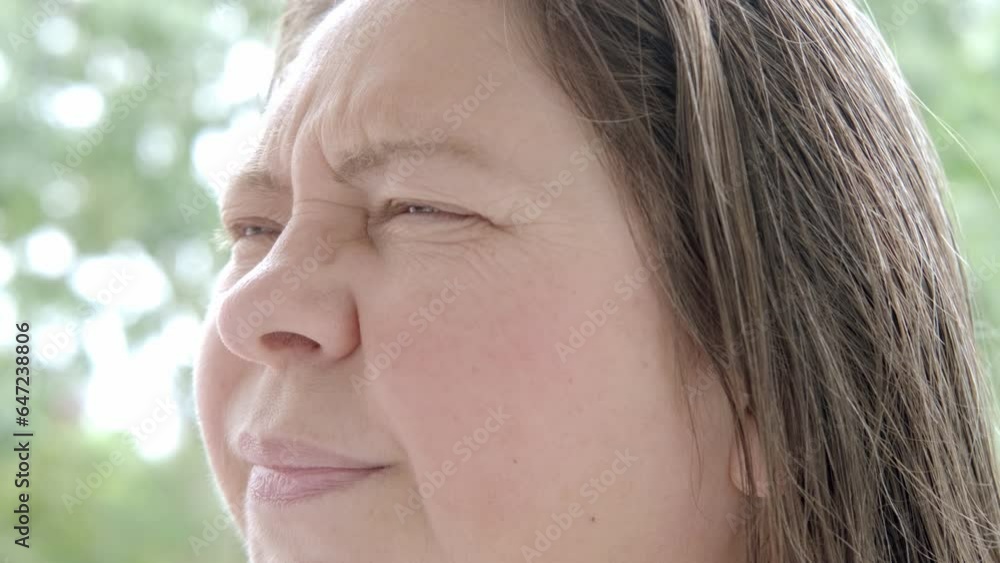 woman 50-55 years old looks into distance, sees poorly, squints, puts ...