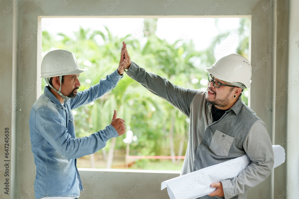 Indian architect with mustache and an Asian male foreman touching their ...