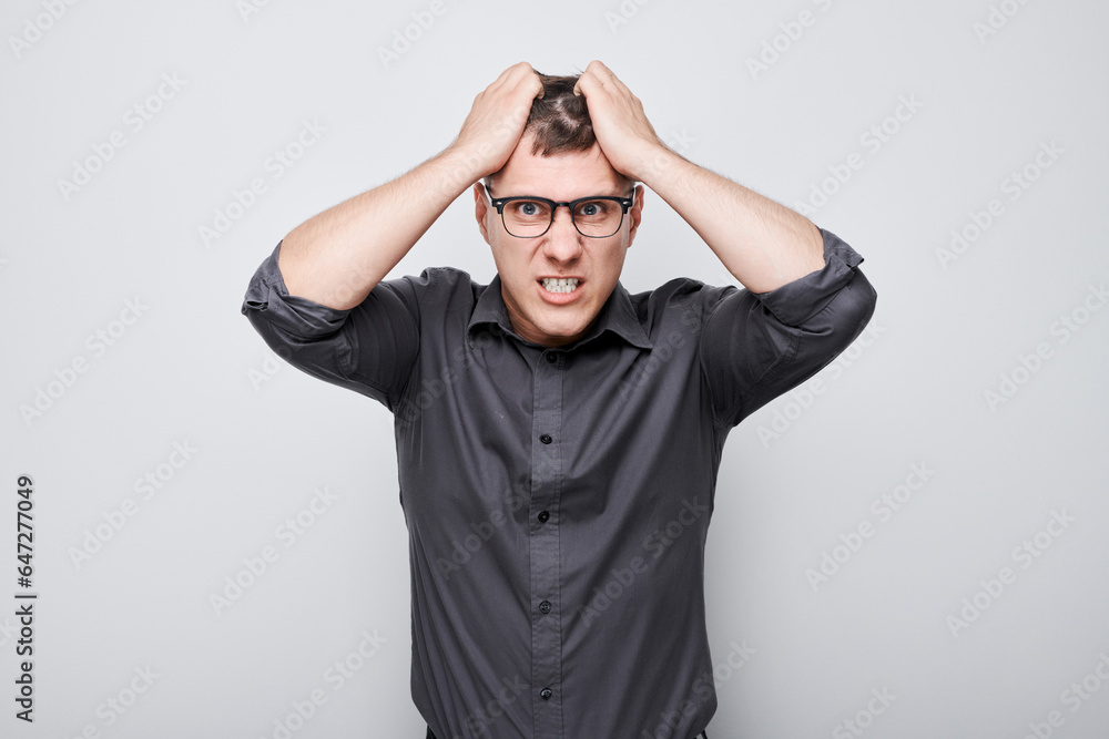 Portrait of angry young man screaming tearing hair out of head isolated ...