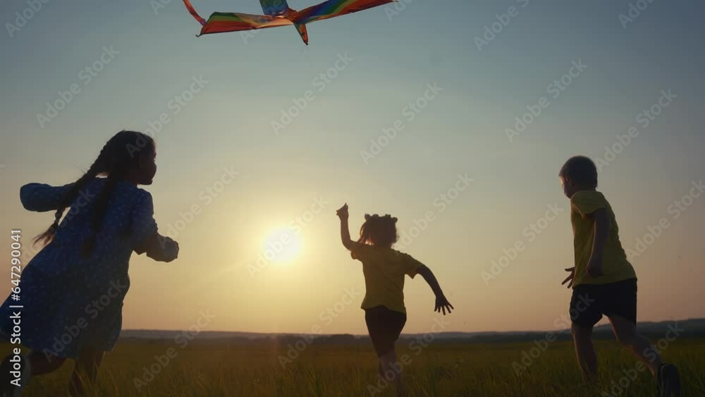 children run with a kite in the park. happy family kid dream concept. a ...