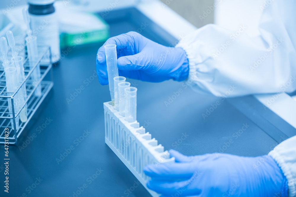 Close up scientist wearing blue gloves working with test tube in the ...