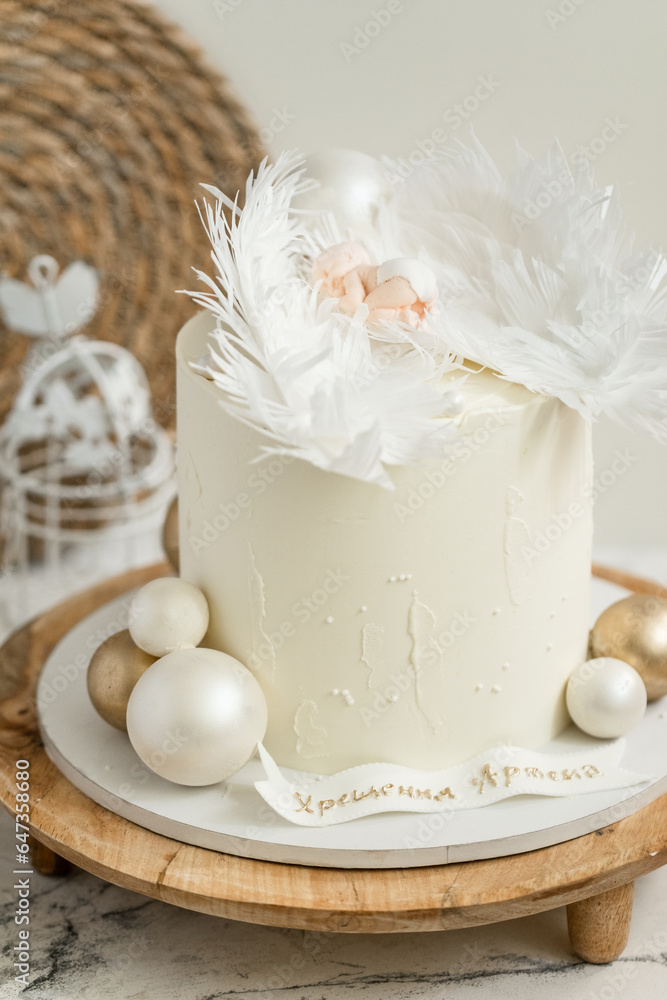 Christening cake with white cream cheese frosting decorated with mastic newborn baby sleeping on ...