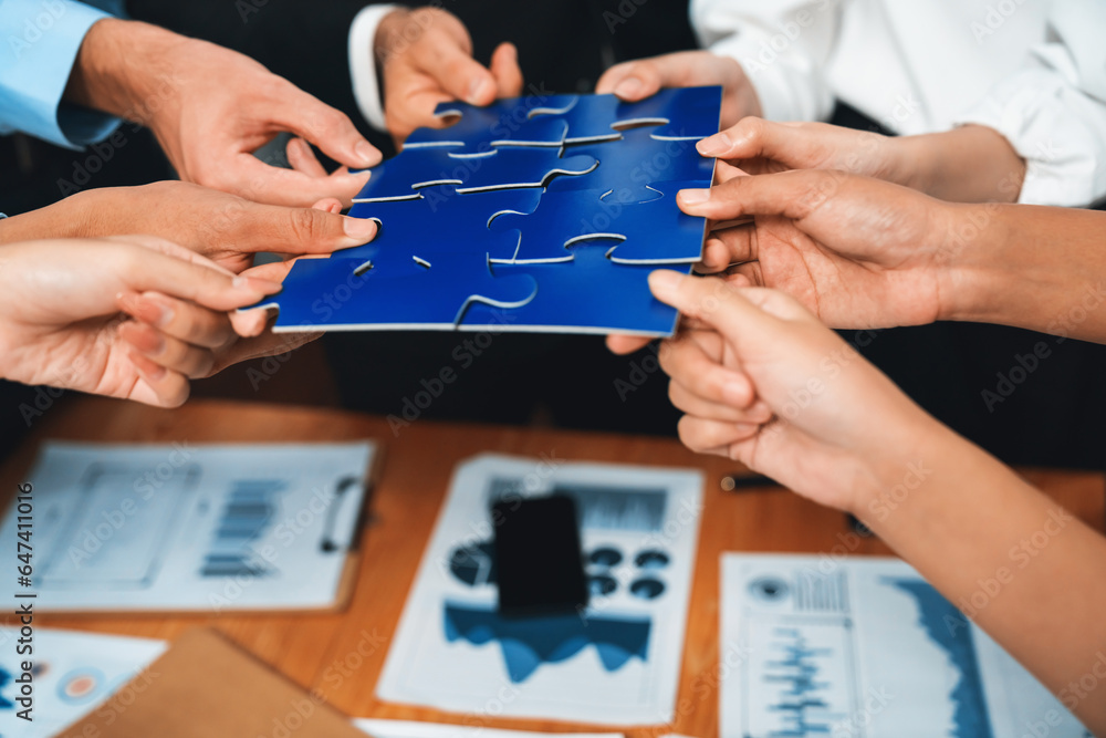 Multiethnic business people holding jigsaw pieces and merge them ...