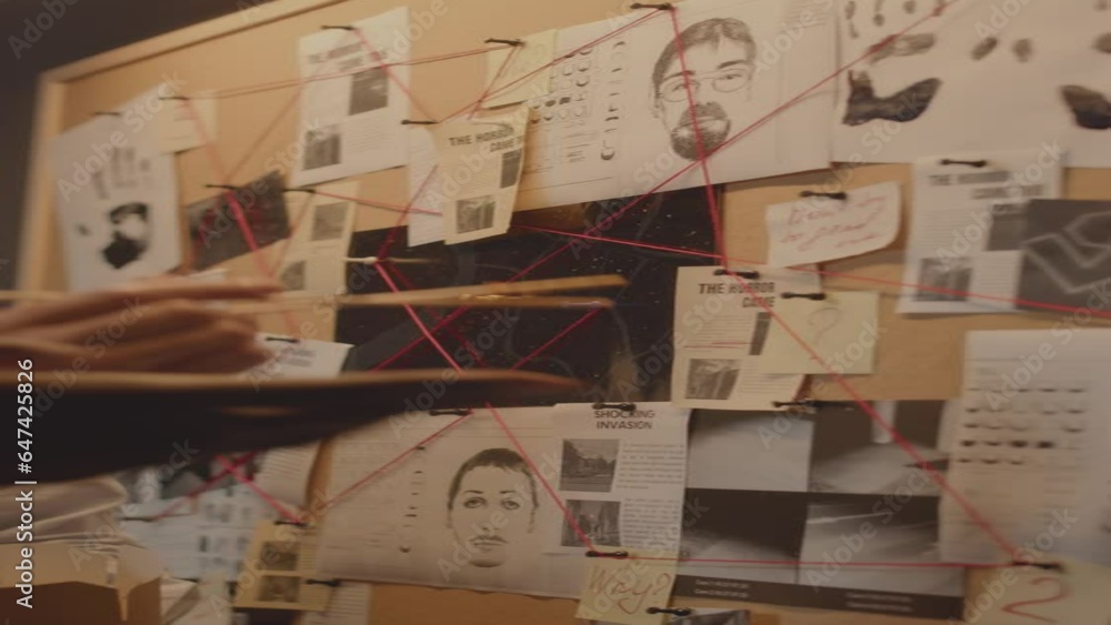 Vertical shot of unrecognizable agents using newspaper clippings, crime ...
