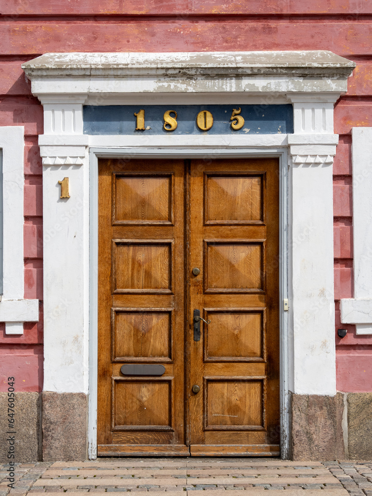 Large wooden door with the number 1 on the white door frame and the ...