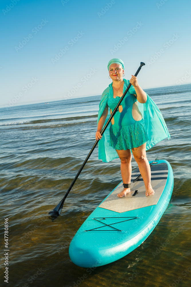 A Jewish woman in a turquoise swimsuit with a skirt and a scarf on her ...