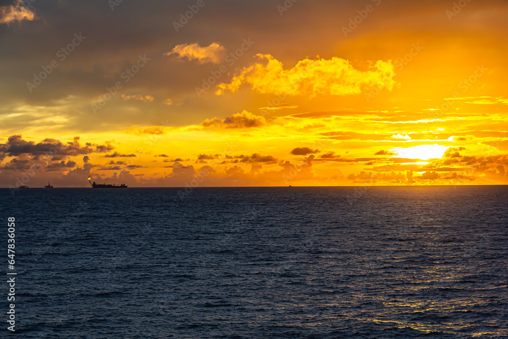 Offshore work area, ships, towers, and FPSO. Beautiful sunset at sea ...
