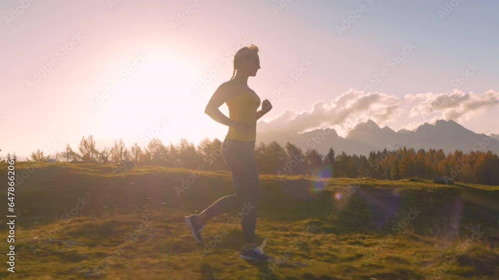 CLOSE UP, LENS FLARE: Athletic woman in sportswear runs on top of a ...