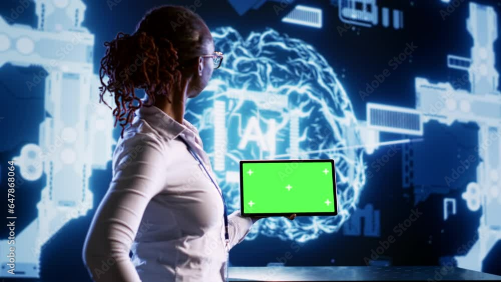 Tech savvy admin in data center with mockup tablet using artificial intelligence computing ...