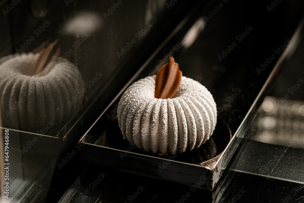 Beautiful sweet white round dessert with chocolate on the vitrine on ...