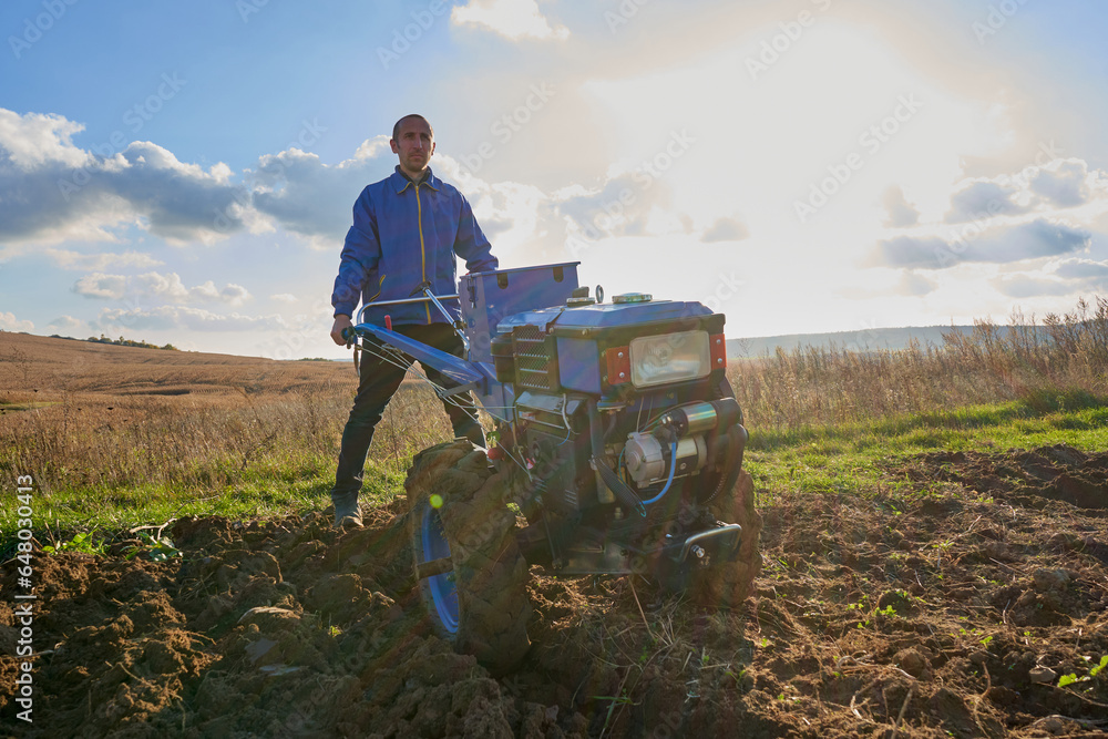plowing with a tractor at sunset,work in the fall in the field, a man ...