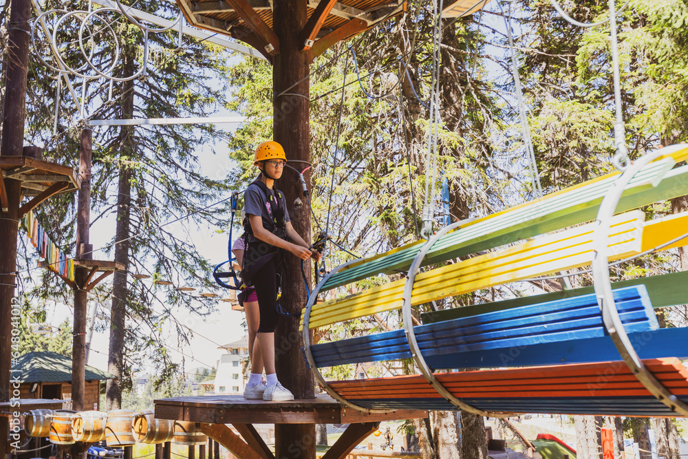 Adventure park fun, child girl pass obstacles in forest at summer camp ...