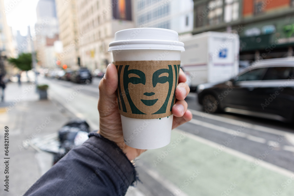 Foto de Starbucks To Go Coffee Cup with a Cardboard Sleave Held by a ...