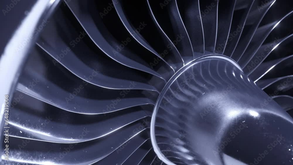 A large jet engine turbine full screen, with a lot of silver blades ...