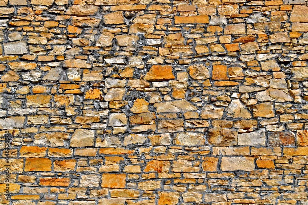 Fieldstone wall. Pieces of different sizes and shapes fitted together ...