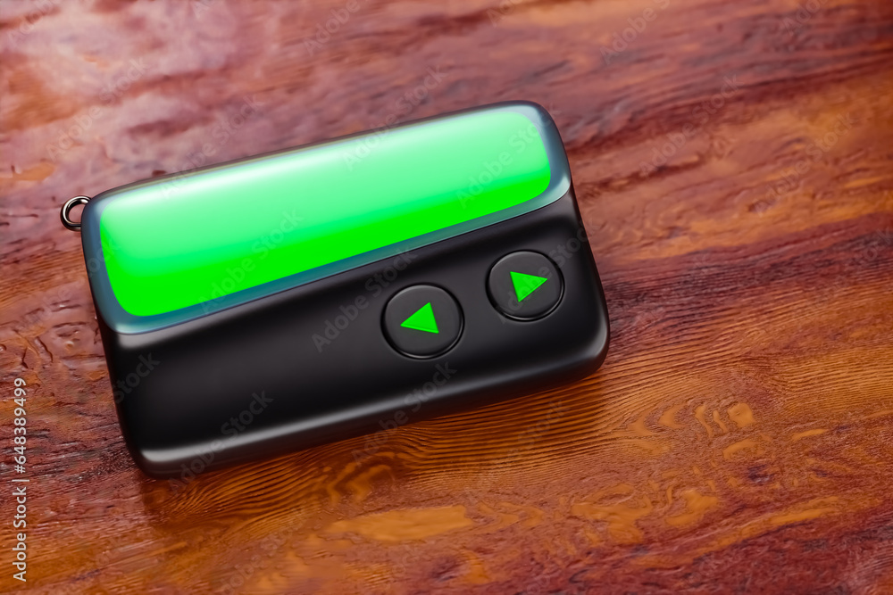 A pager or beeper is shown in a 3D rendering on a wooden tabletop. One ...