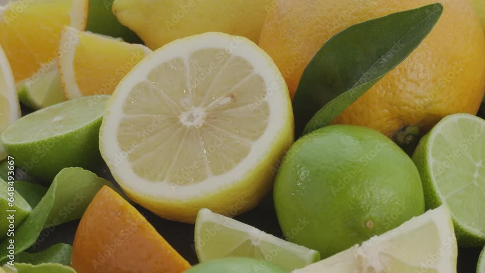 Ripe citruses fruits with slices and citrus leaves slowly move in the ...