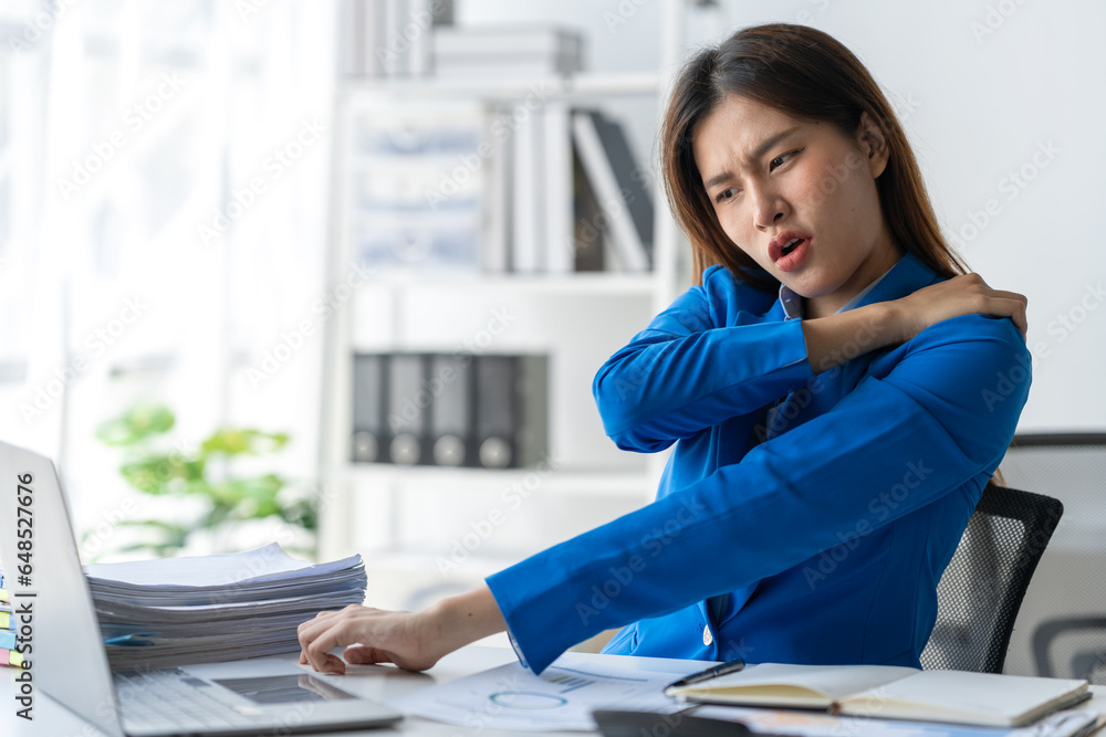 Young businesswoman having pain and fatigue in her shoulders and neck ...