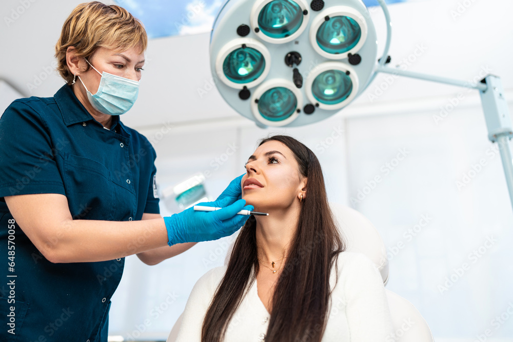 Beautiful and happy brunette woman at beauty medical clinic. She is ...