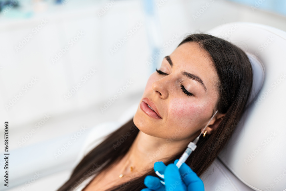 Beautician is contouring the woman's cheekbones with hyaluronic acid ...